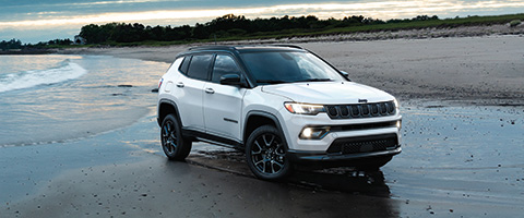 2024 Jeep Compass parked on the edge of a lake.