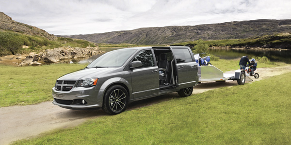 Parked Grey 2020 Dodge Grand Carvan with towed motorbikes