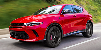 2024 Hornet R/T in Hot Tamale driving along a road with green trees in ...